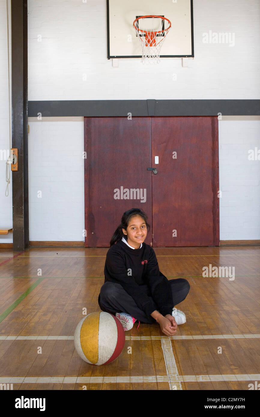 A girl sat crossed legged on the floor of a school gymnasium Stock ...