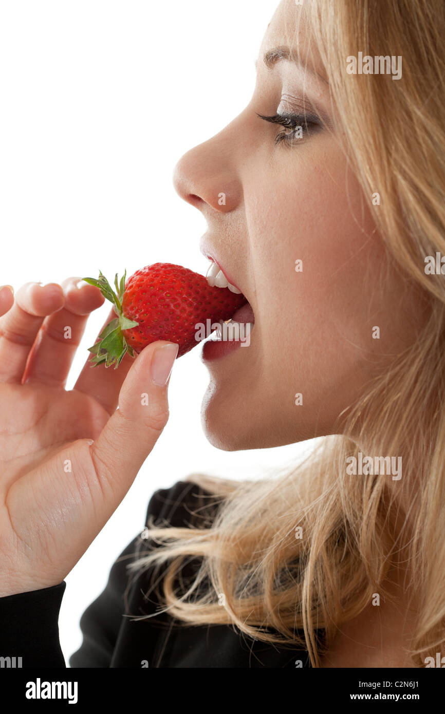 Beautiful profile of a caucasian woman biting strawberry Stock Photo ...