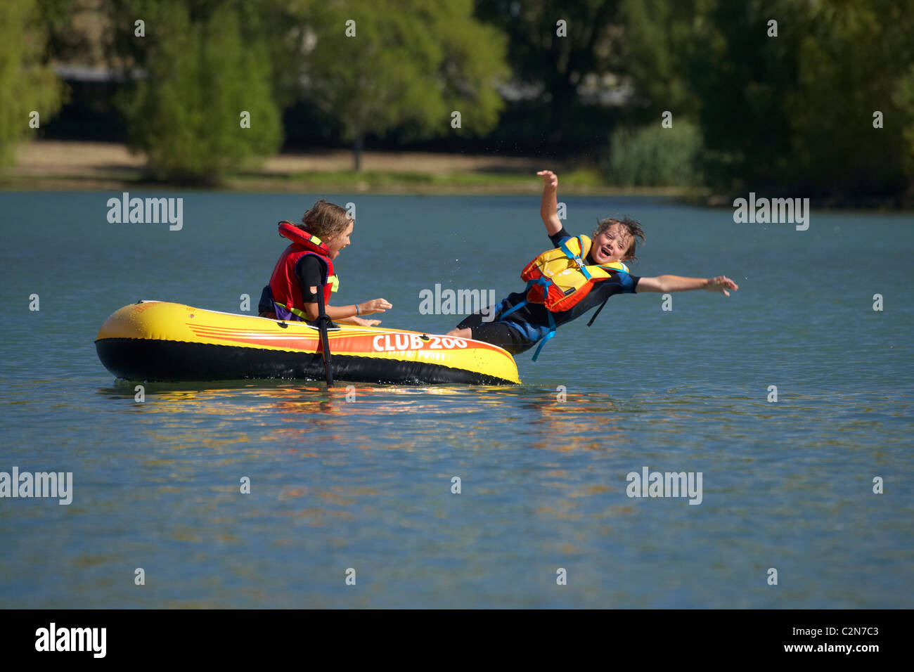 Children jumping from inflatable boat, Bannockburn Inlet, Lake Dunstan ...