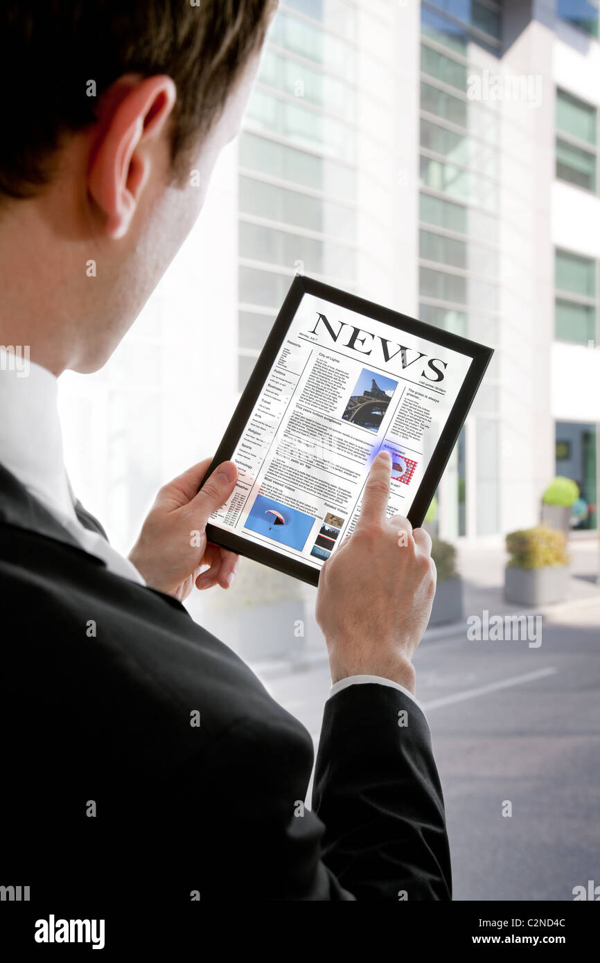Businessman holding a touchpad pc and reading a newspaper Stock Photo ...