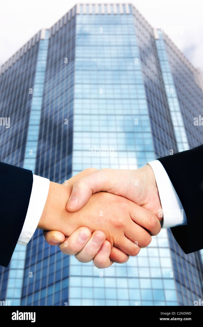 Business handshake against office building Stock Photo - Alamy