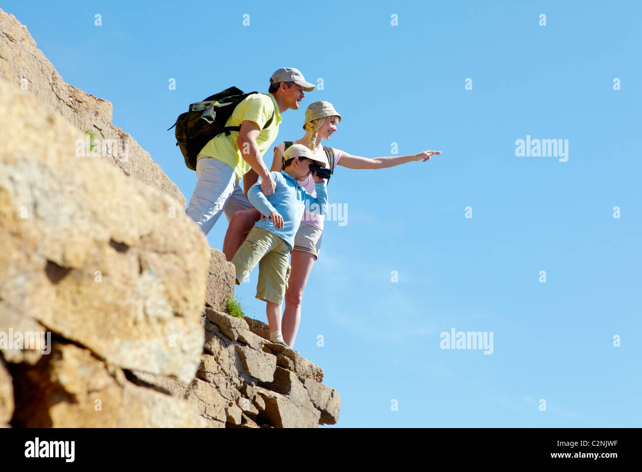 Portrait of family members looking afar outside while standing on cliff ...