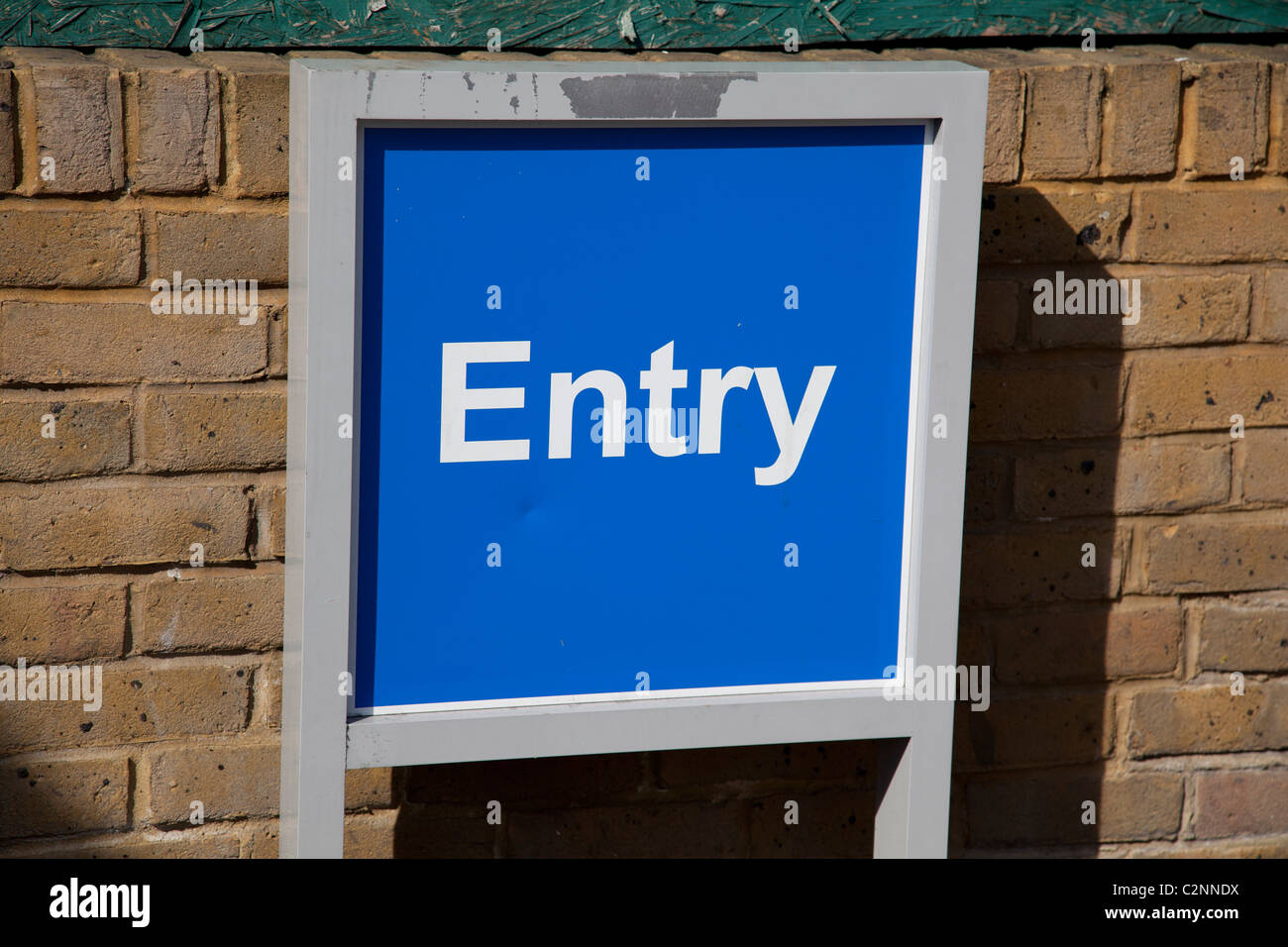 Entry sign against brick wall Stock Photo - Alamy