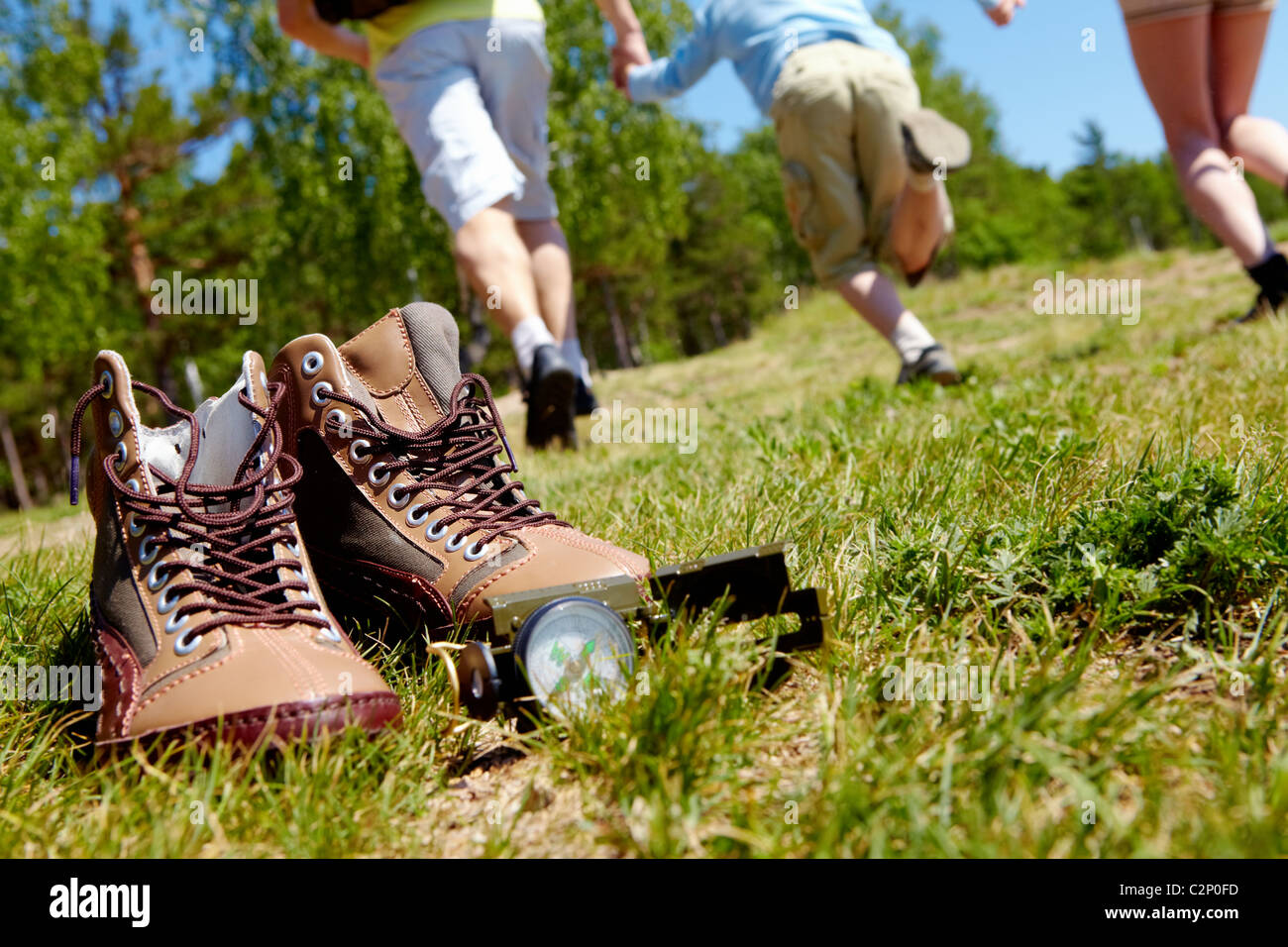 Image of pair of boots and compass on background of people running down ...