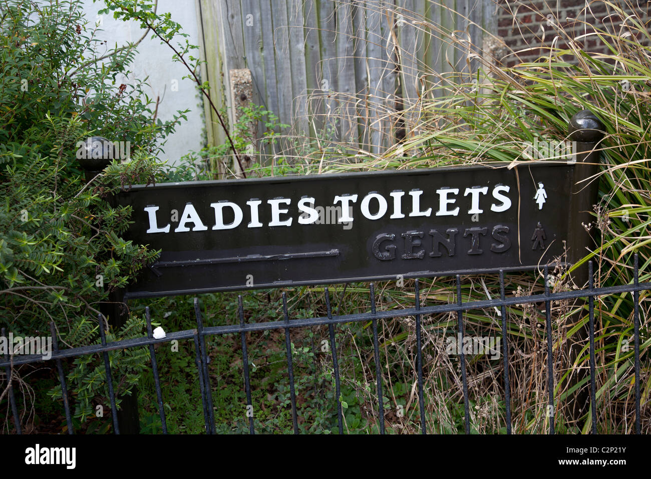 Toilets ladies gents arrow signpost park Stock Photo - Alamy