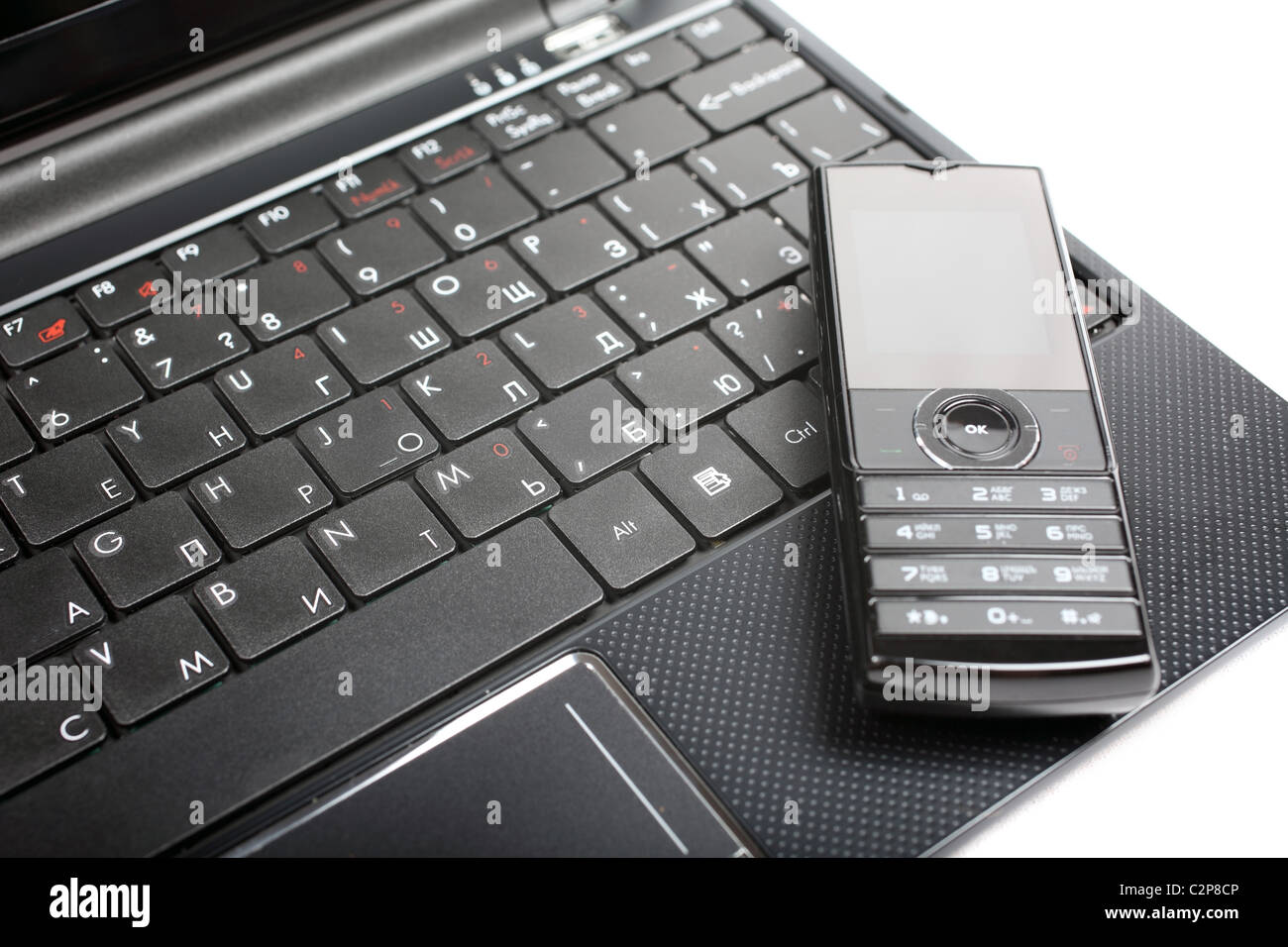 Mobile phone laying on notebook isolated on white background Stock ...