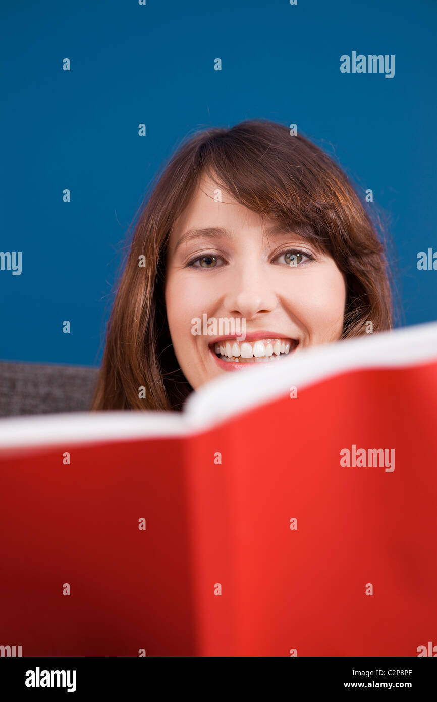 Beautiful and happy young woman reading a book Stock Photo - Alamy
