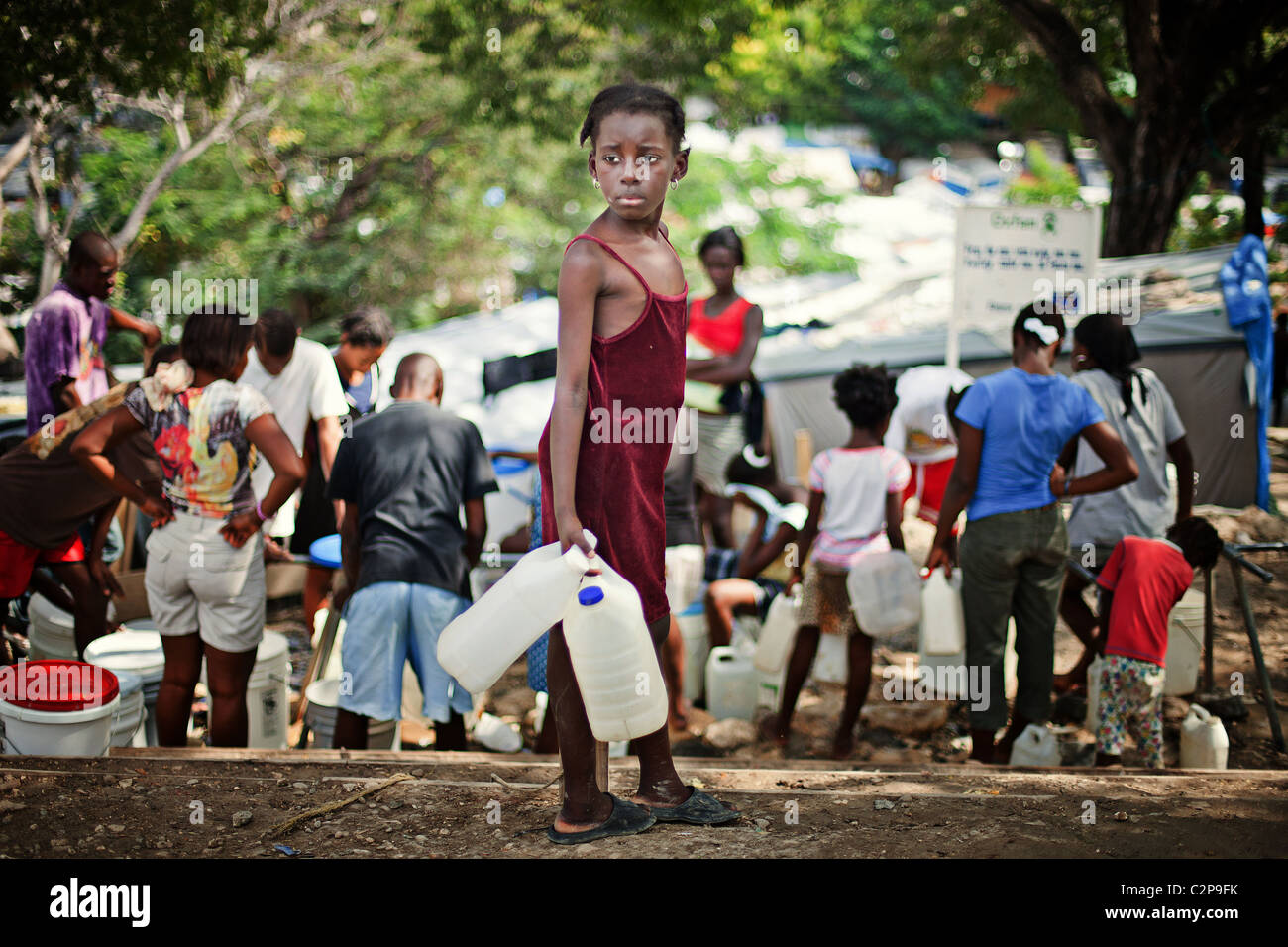 Girl waiting in queue for the water in Petionville tent camp one year ...