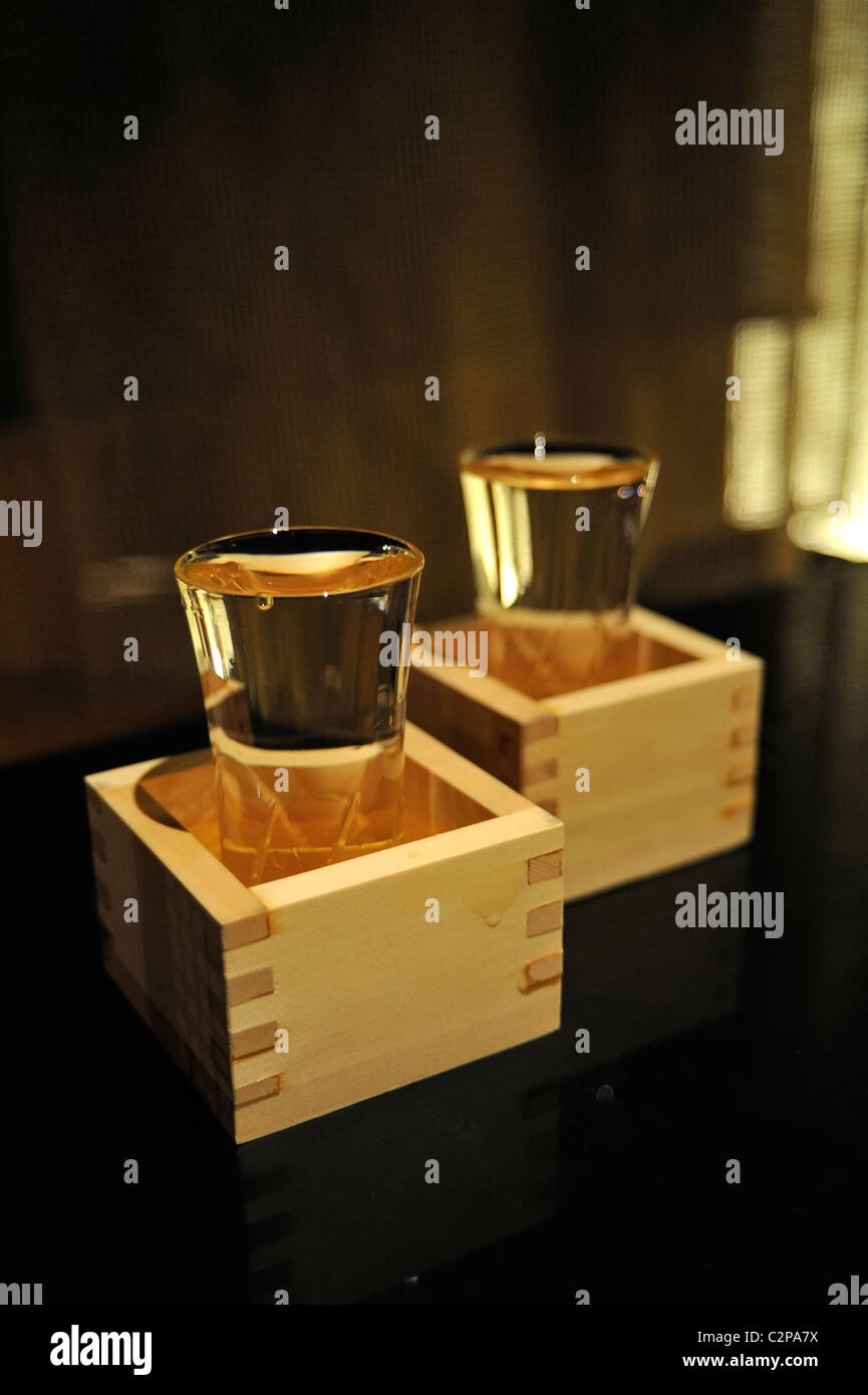 Full sake cups in wooden boxes on a table in a restaurant in Tokyo ...