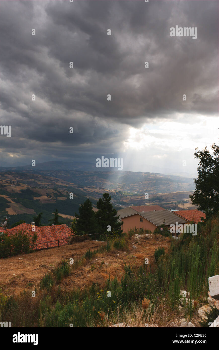 Sun rays through dark gray clouds Stock Photo - Alamy