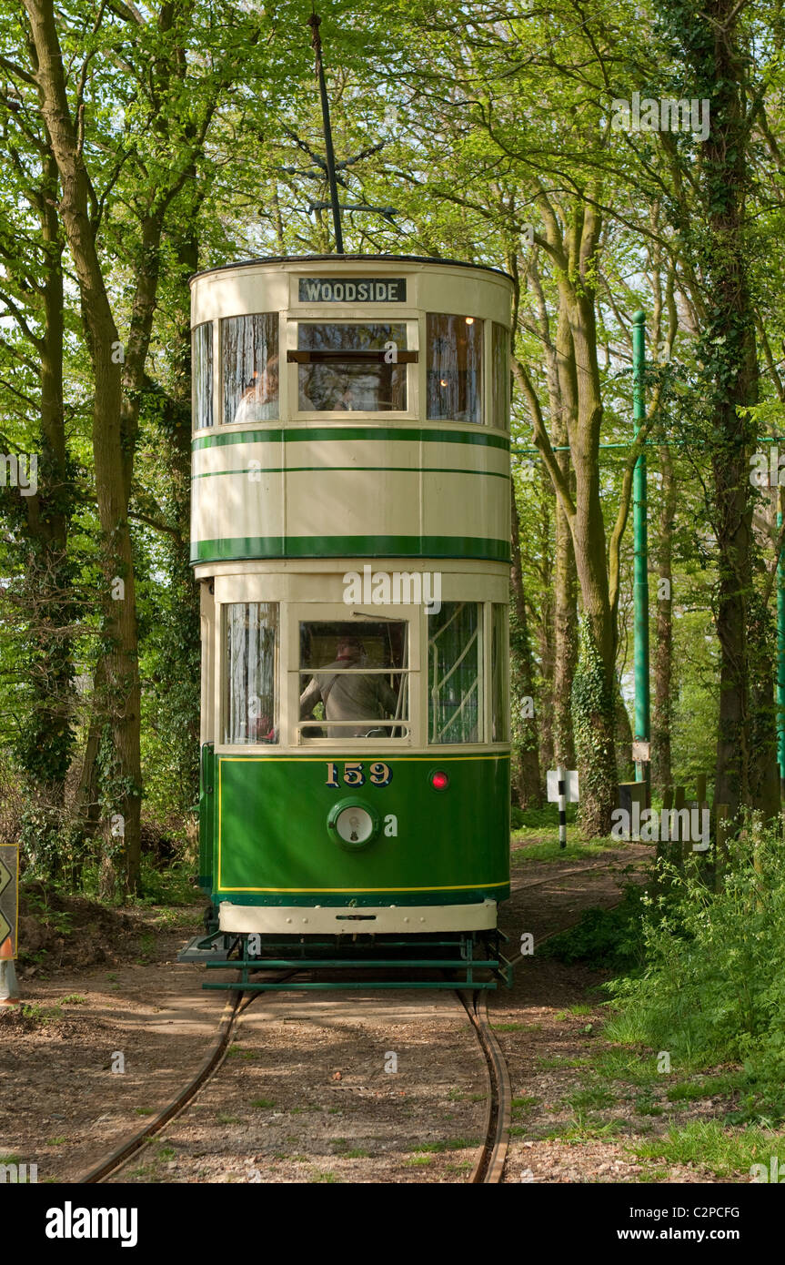 Vintage transport Green & Cream Tram on tram lines. Woodland backdrop ...