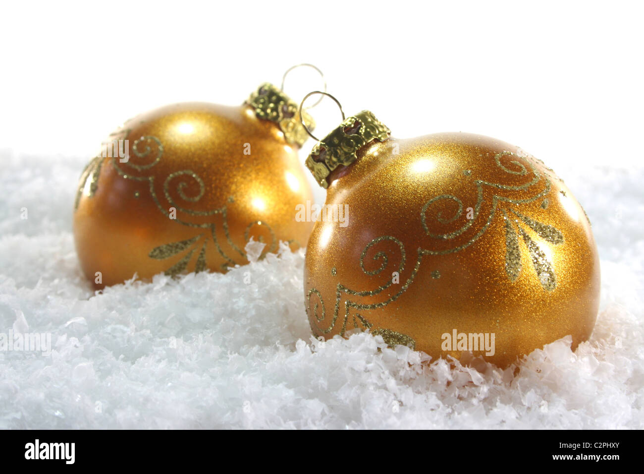 two golden Christmas balls lying in the snow Stock Photo - Alamy