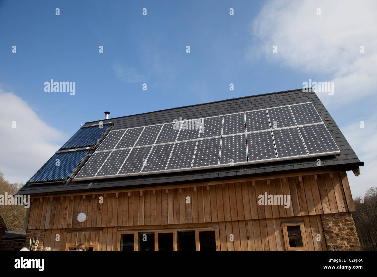 Solar thermal and PV panels on roof of sustainable oak timber building ...