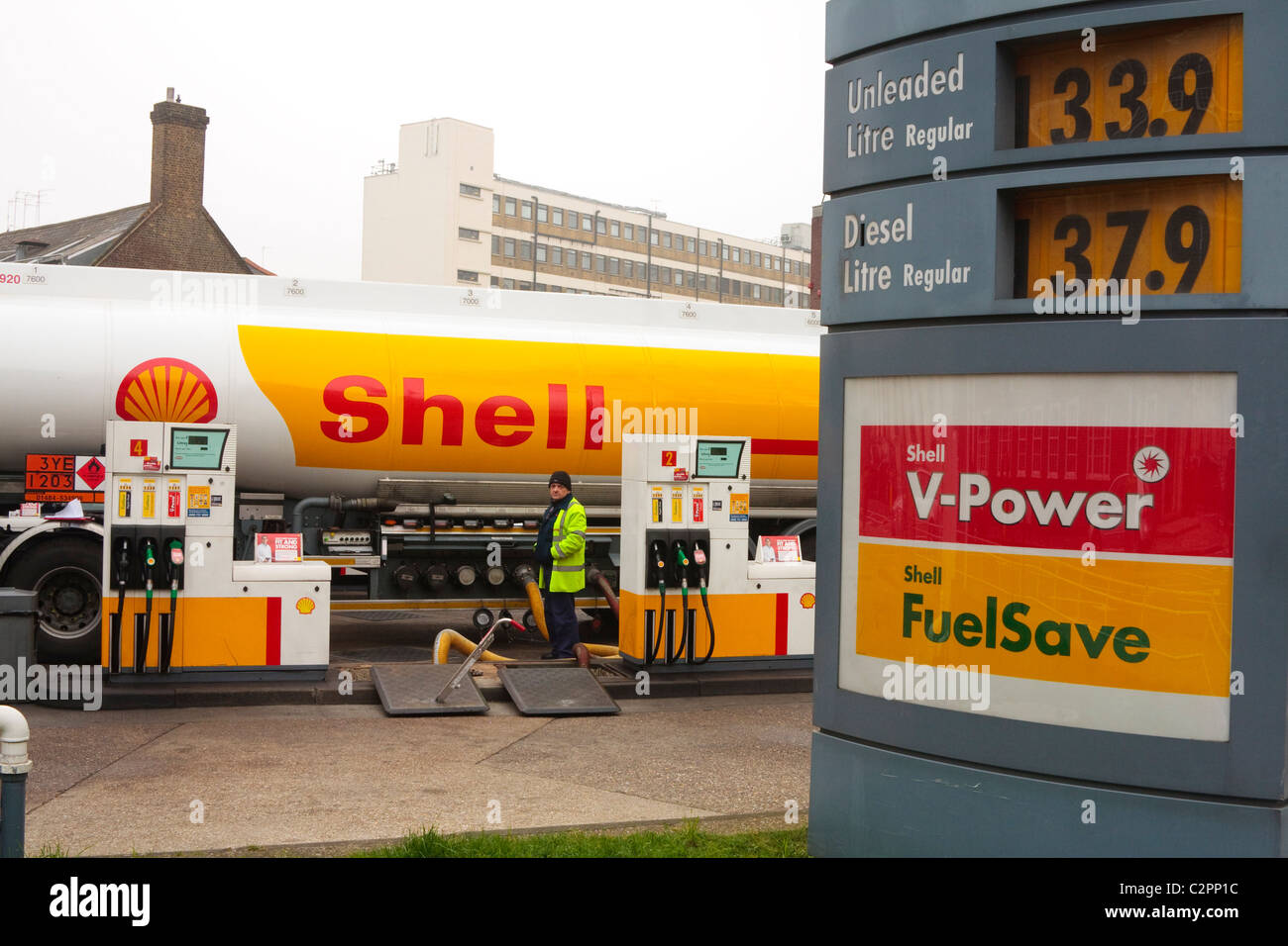 A Shell delivery driver over-seeing the filling up of a Shell petrol ...