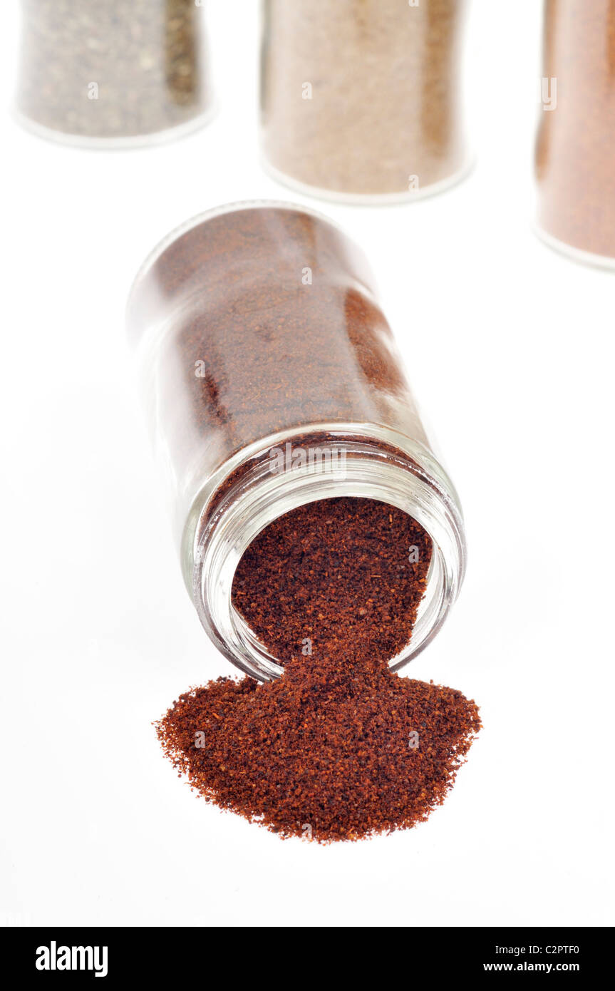 Open bottle of the spice chili pepper on its side with spice spilling ...