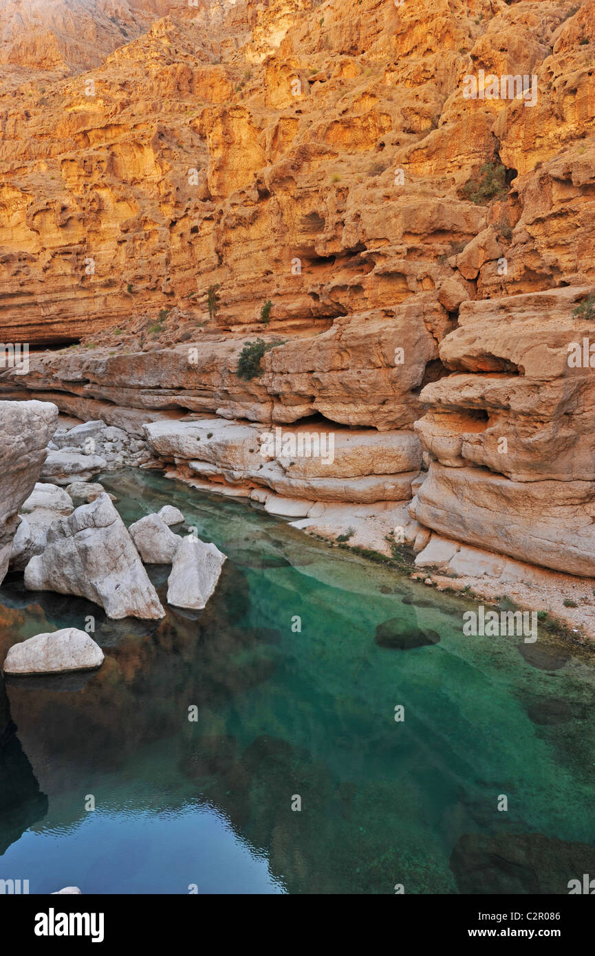 Oman, Wadi Shab, natural pool a with gravels, running alongside sharp ...