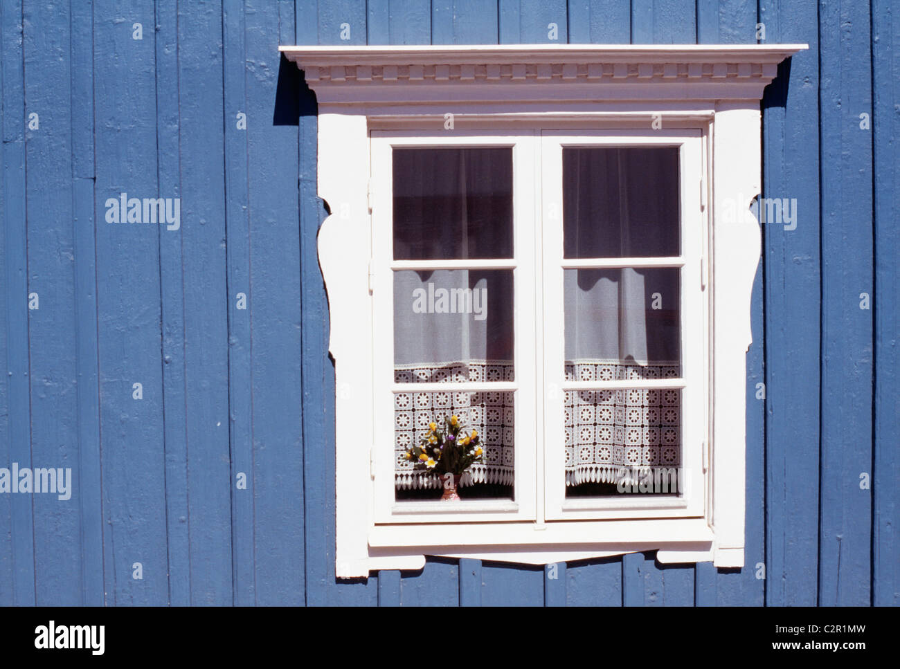 White window on blue wood clad house, traditional Swedish village style ...