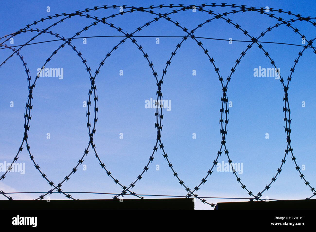 Razor wire surrounding the gasometers, loops of wire Stock Photo - Alamy
