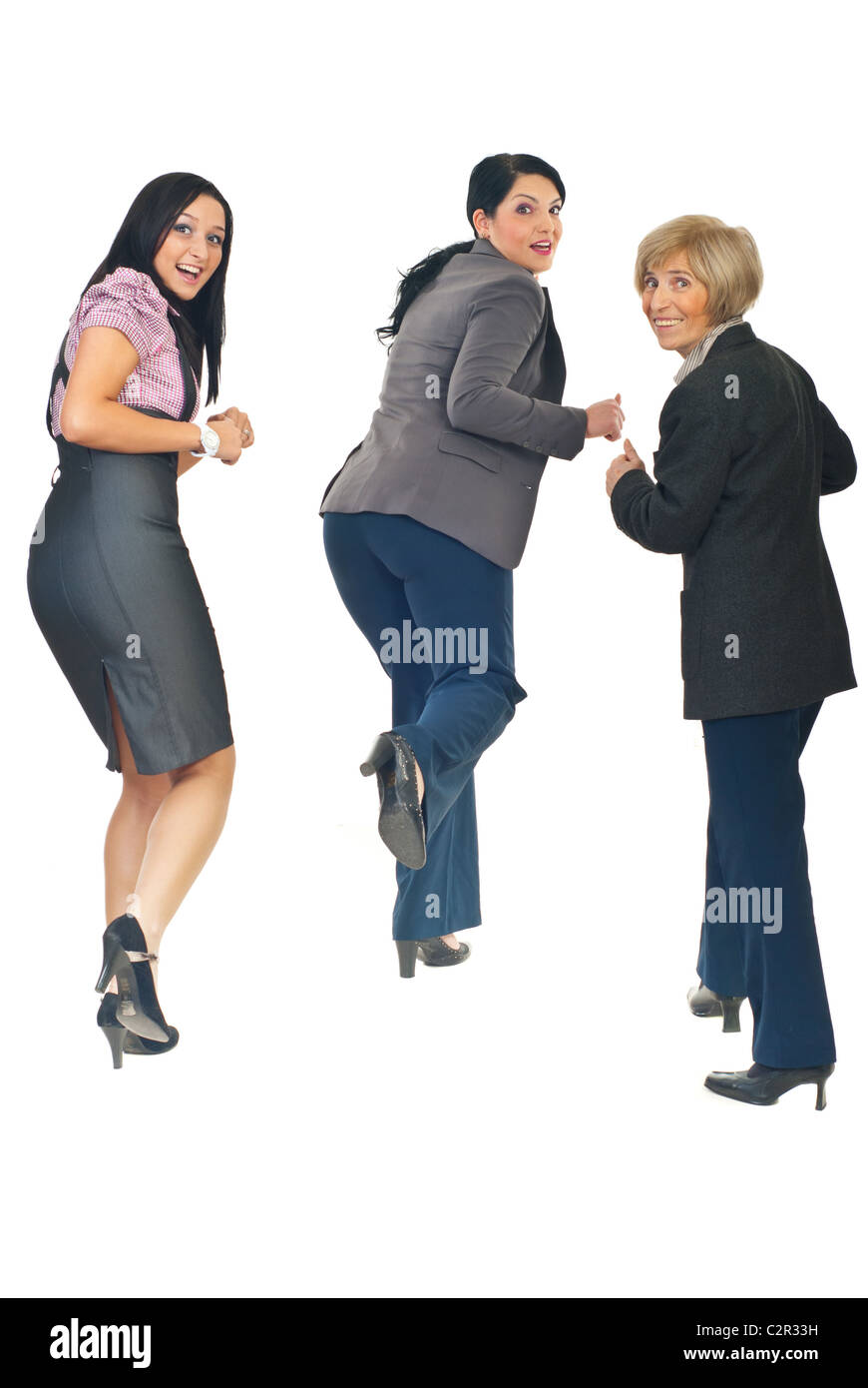 Rear view of three business women running from something or someone ...