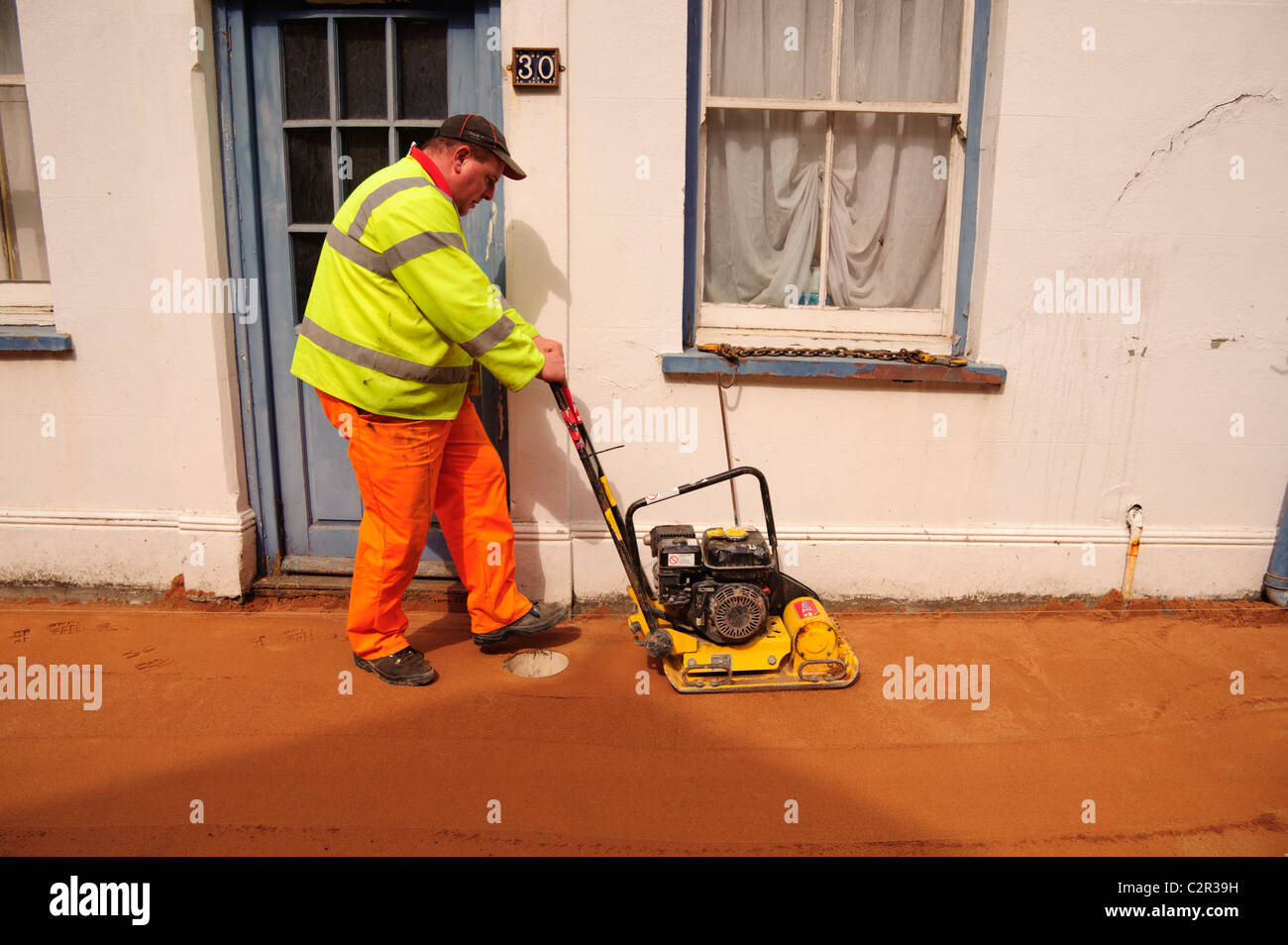 A Local Authority direct labour workmen repairing a street pavement, UK ...