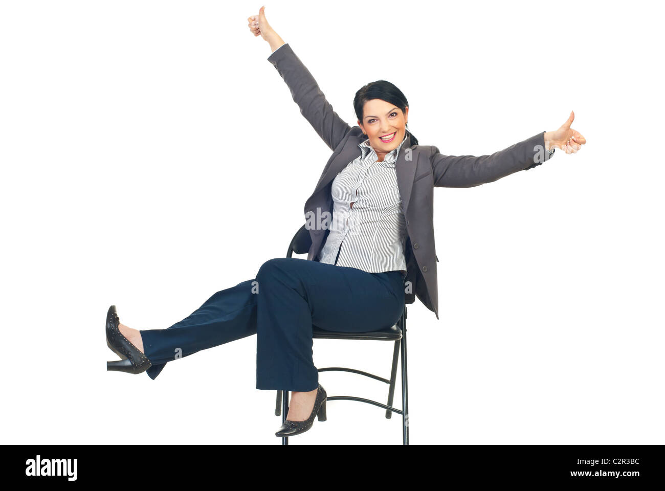 Successful business woman siting on chair raising legs and arms and ...