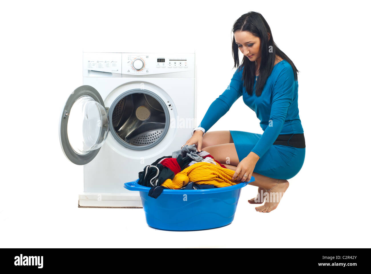 Young woman loading washing machine isolated on white background Stock ...