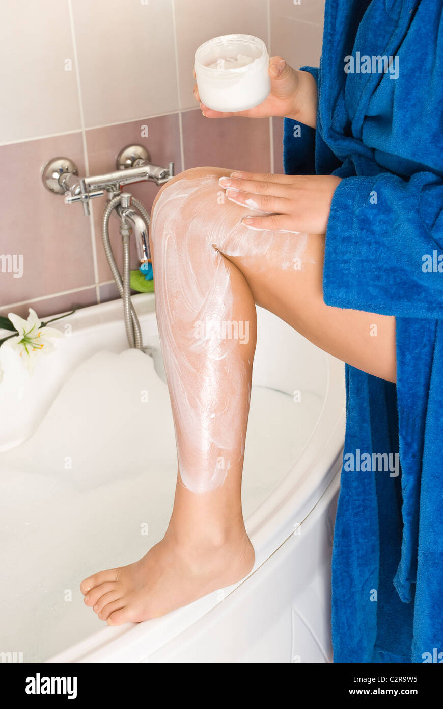 Rubbing cream on her leg hi-res stock photography and images - Alamy