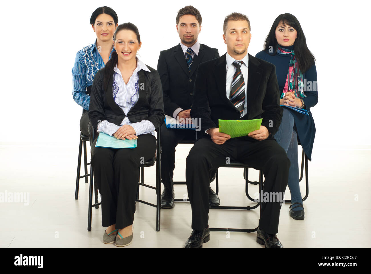 Five business people sitting on chairs at seminar and listening Stock ...