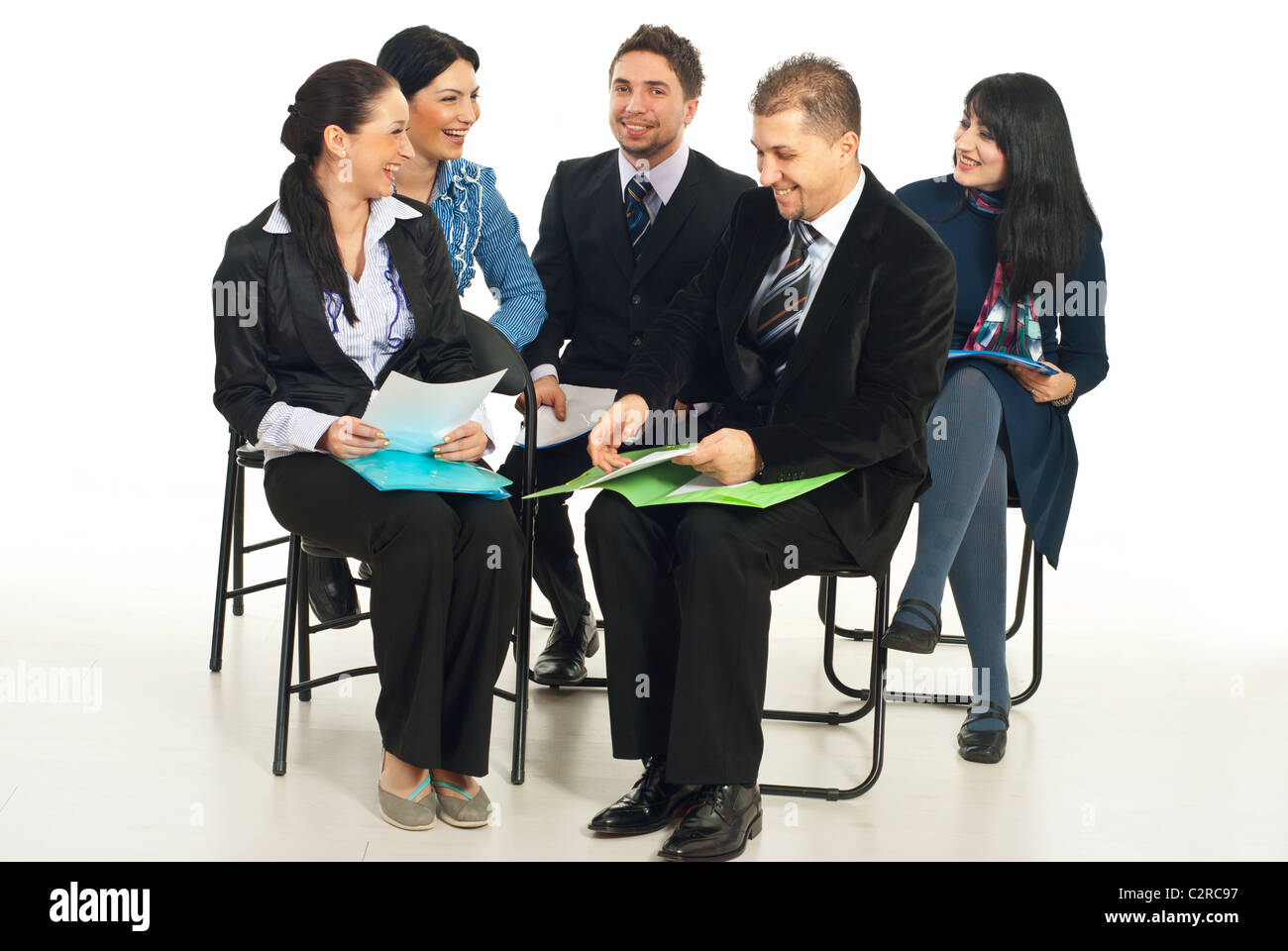 Five business people sitting on chairs at conference and laughing ...
