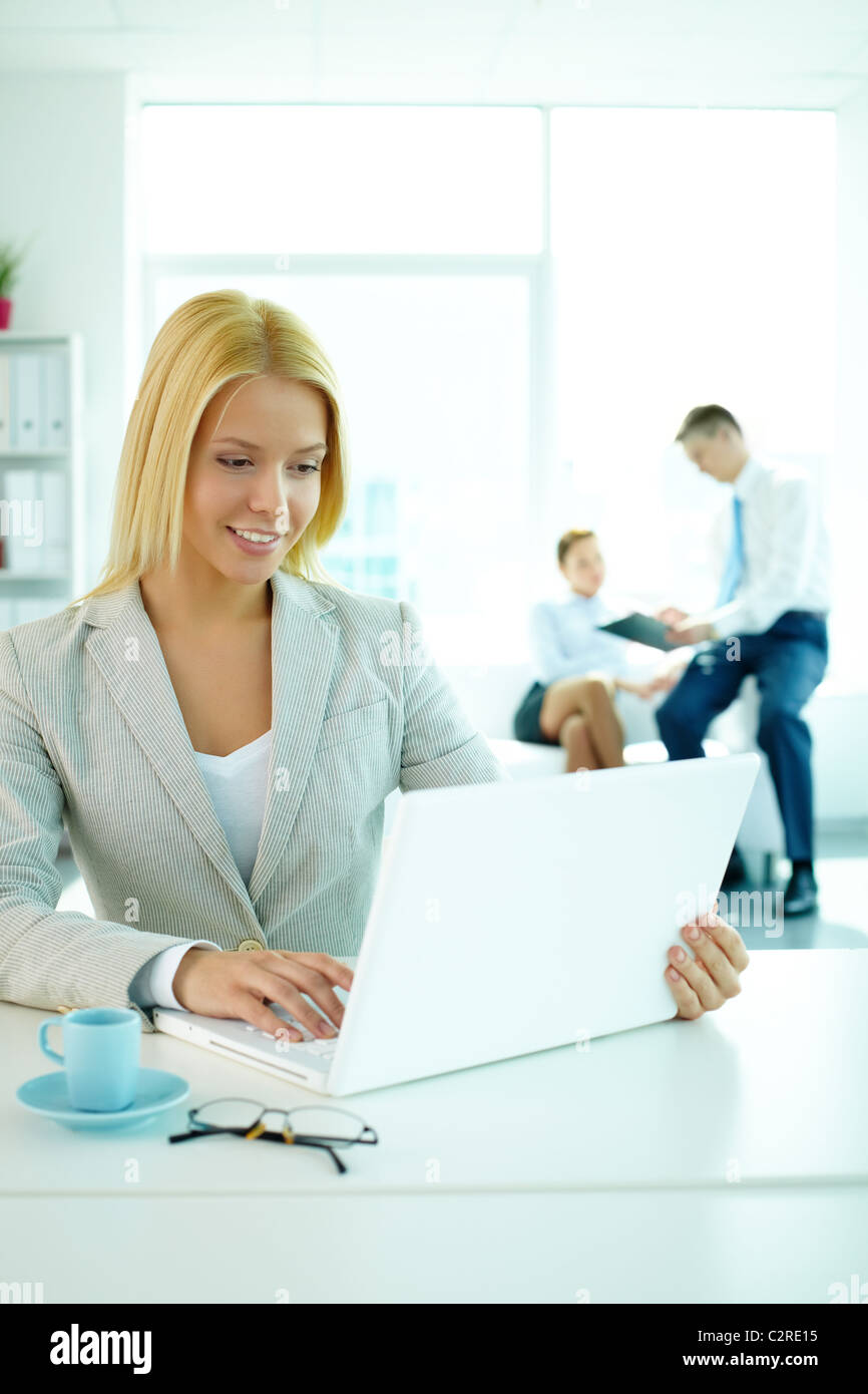 Portrait of pretty secretary looking at laptop screen in working ...