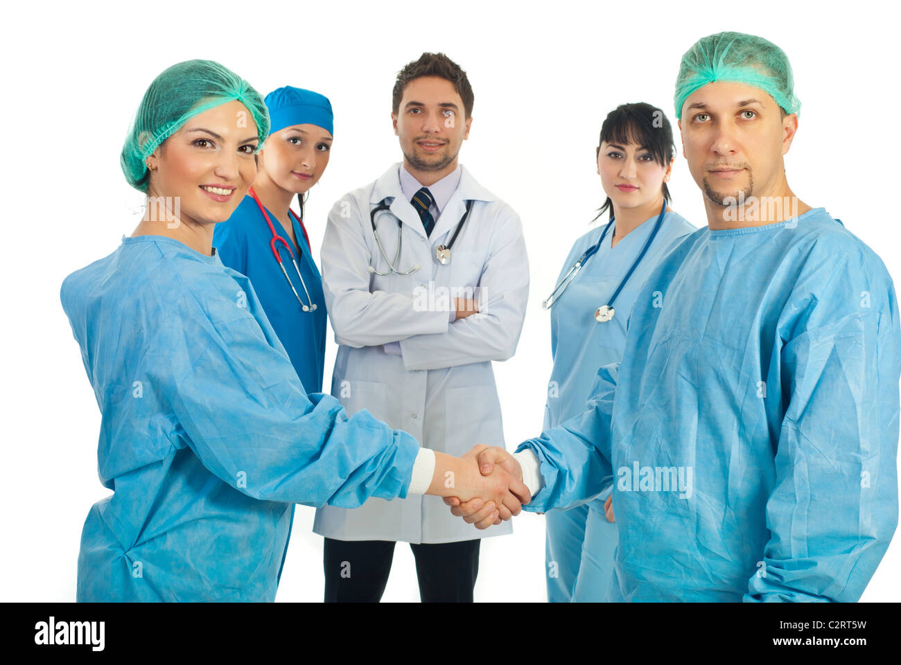 Two surgeons giving handshake and their team smiling in background ...