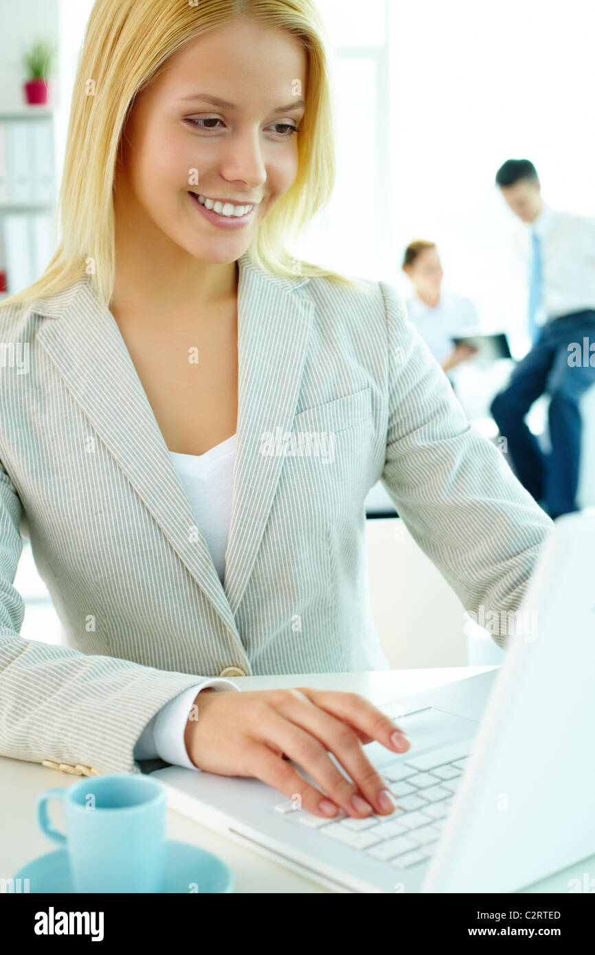Portrait of pretty secretary looking at laptop screen in working ...