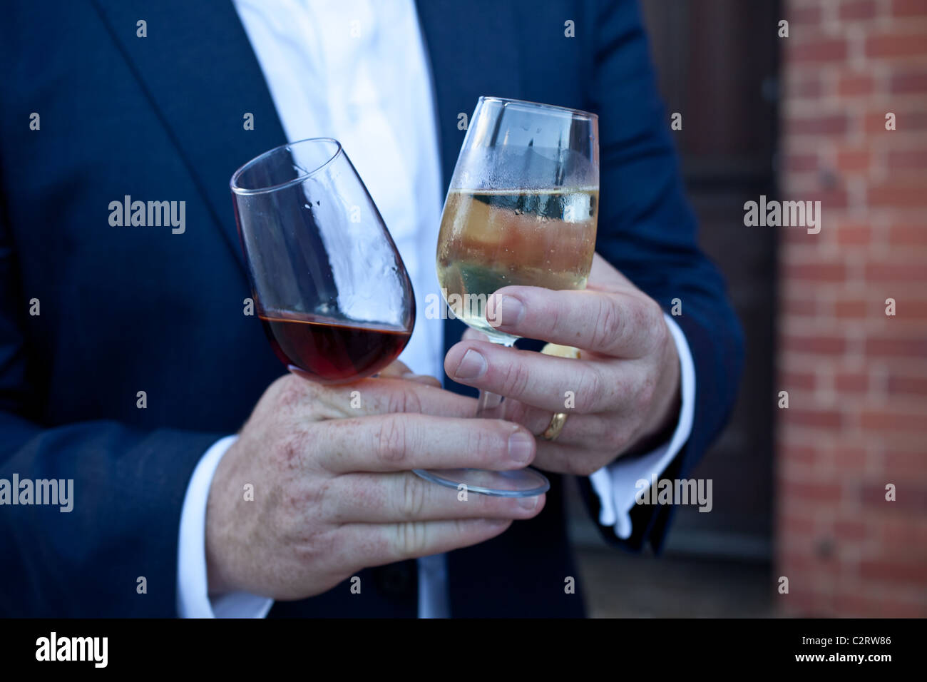A man with two alcoholic drinks in his hands Stock Photo - Alamy