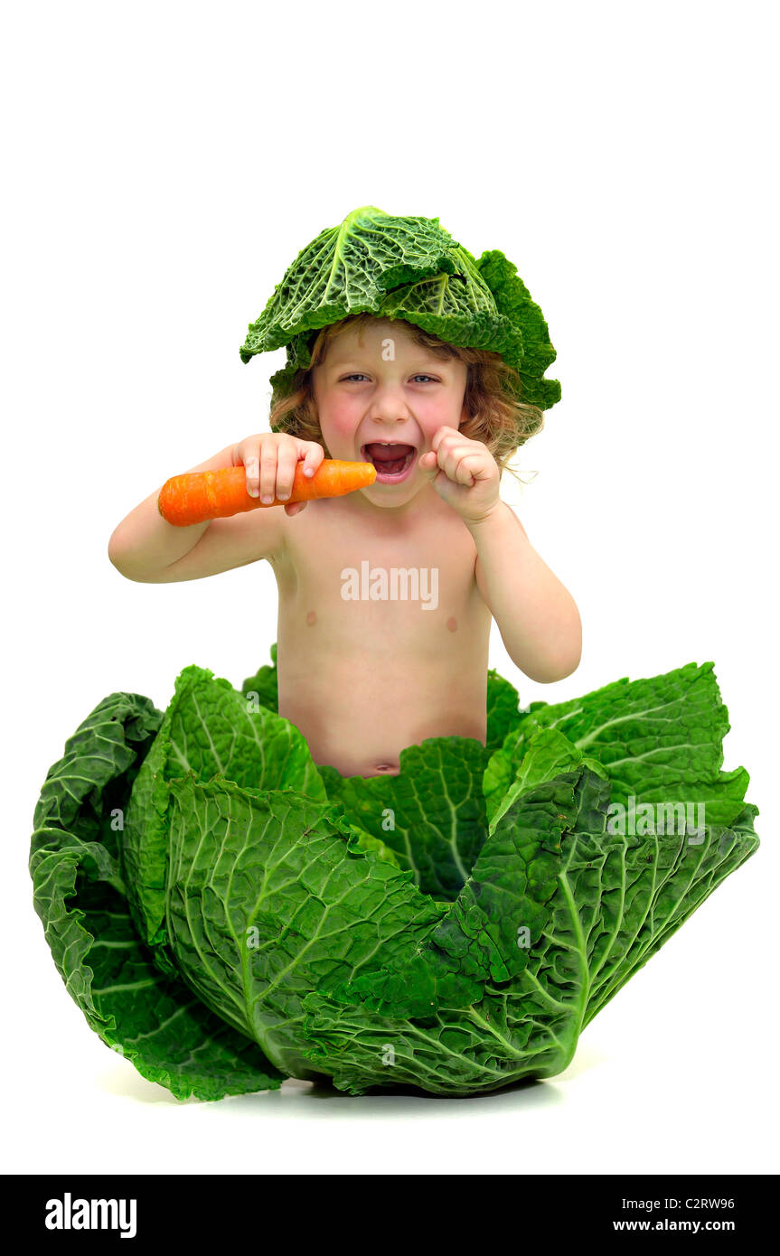 Beautiful young boy inside a cabbage eating carrots Stock Photo - Alamy