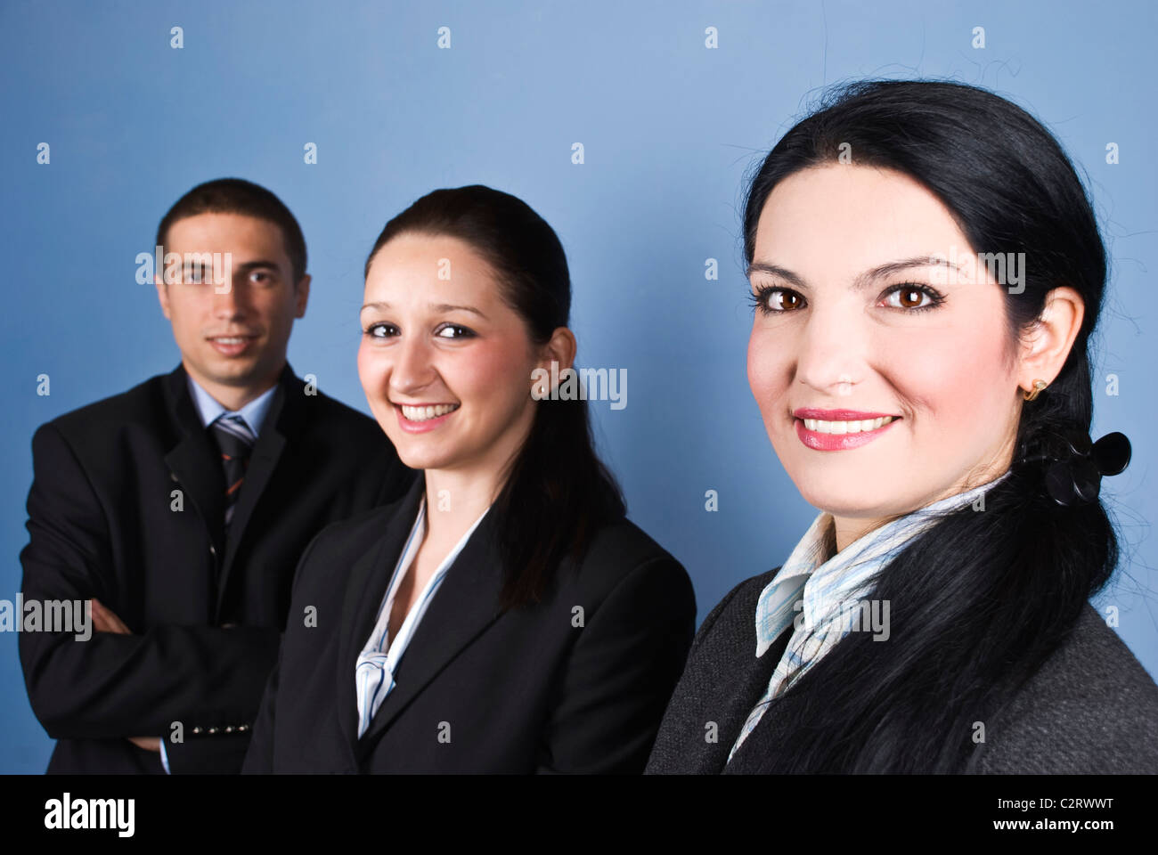 Cheerful group of three business people standing in semi profile and ...