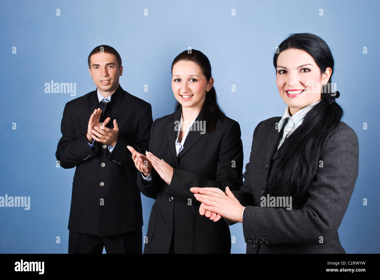 Business people clapping their hands and standing in front of blue ...