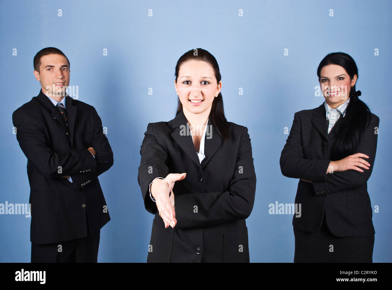 Business women giving welcome gesture in the middle of her colleagues ...