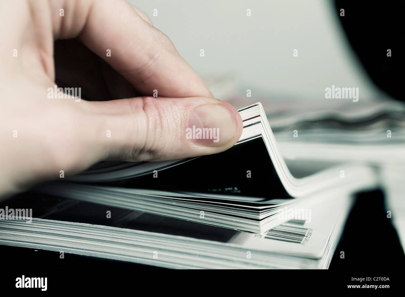 Man's hand turned over a stack of magazines closeup Stock Photo - Alamy