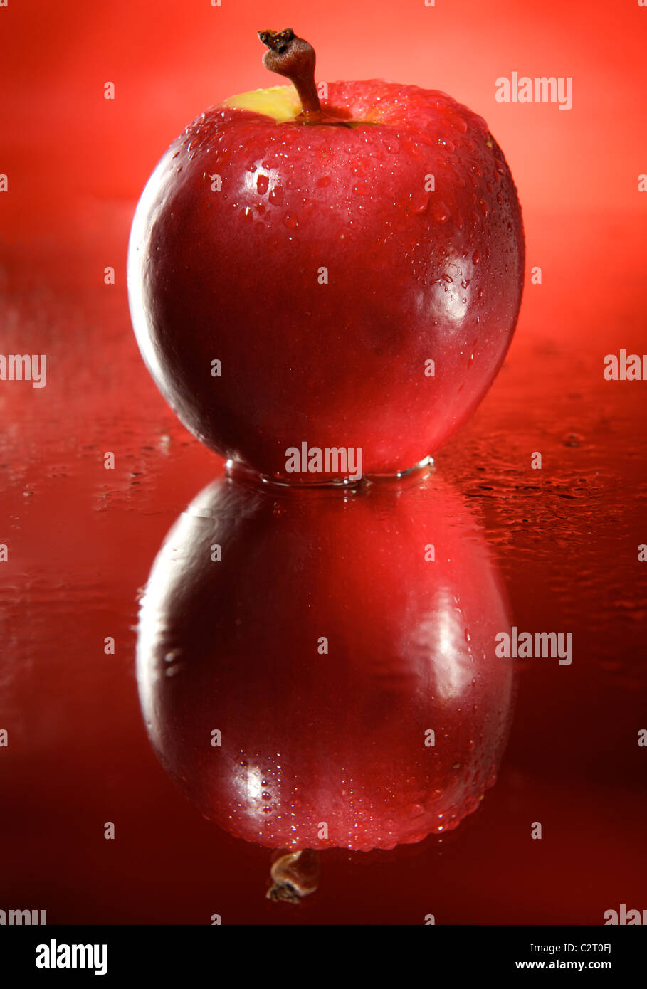One red apple with droplets on the mirror and red background Stock ...