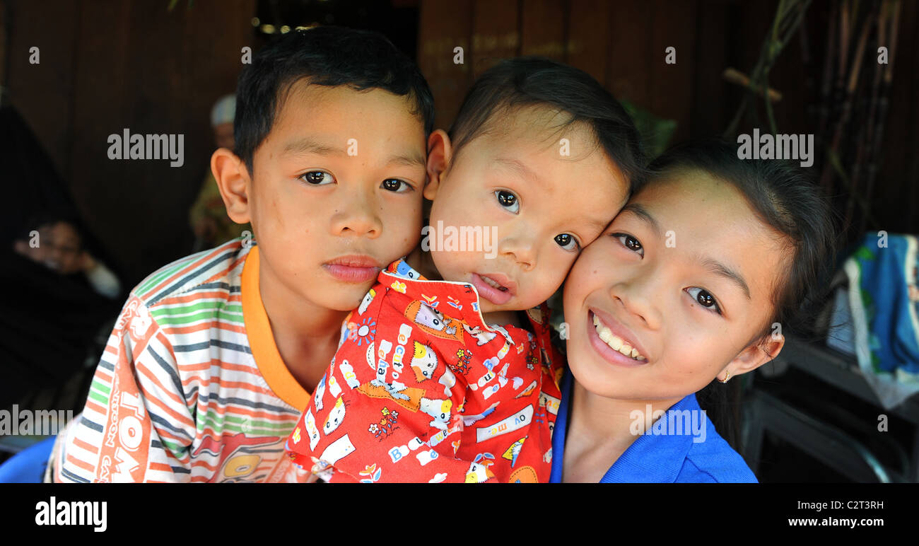 three kids posing in market for camera Stock Photo - Alamy