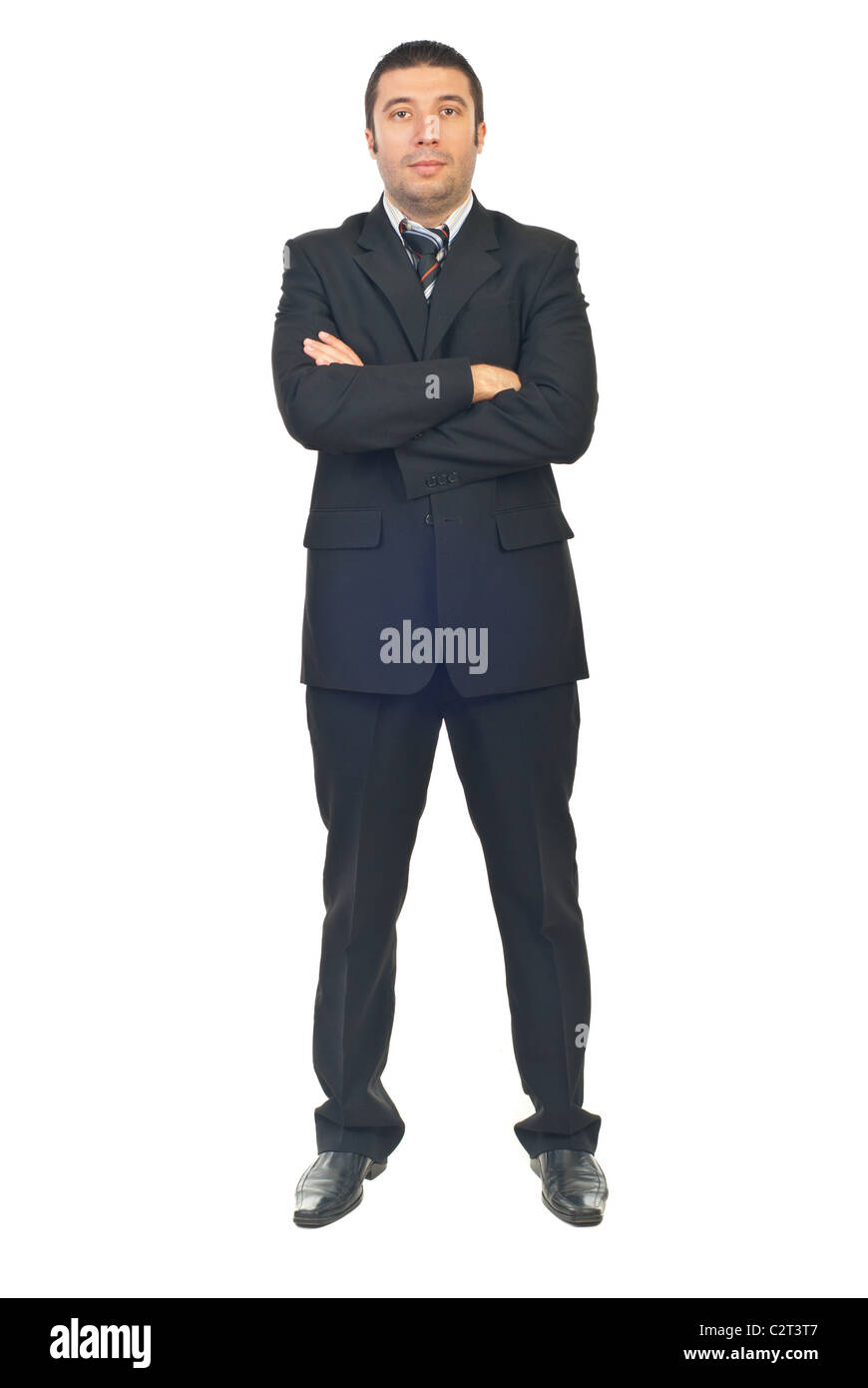 Full length of serious business man standing with arms folded isolated ...