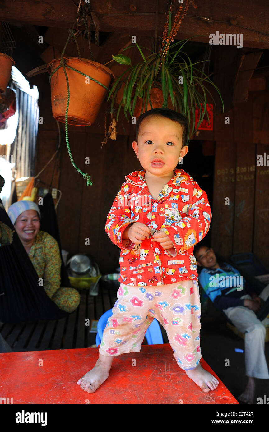 Infant standing on table looking straight at camera Stock Photo - Alamy