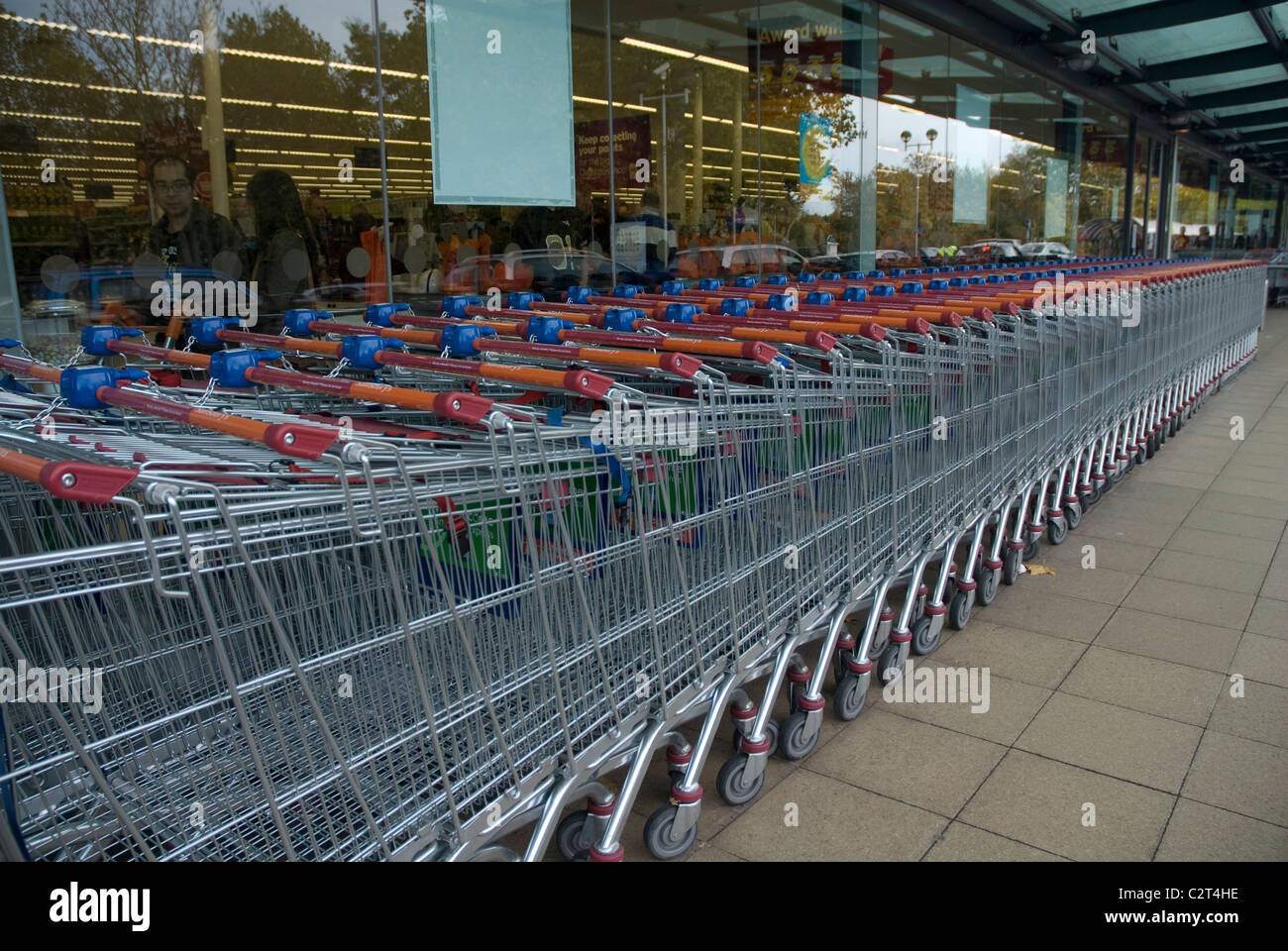 Row of stacked shopping trolleys outside a supermarket in Bath Somerset ...