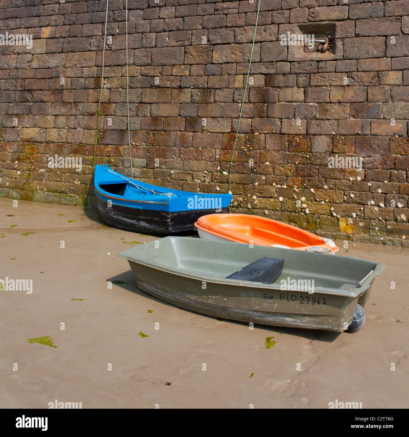 Three boats on sand, wall in bricks Stock Photo - Alamy
