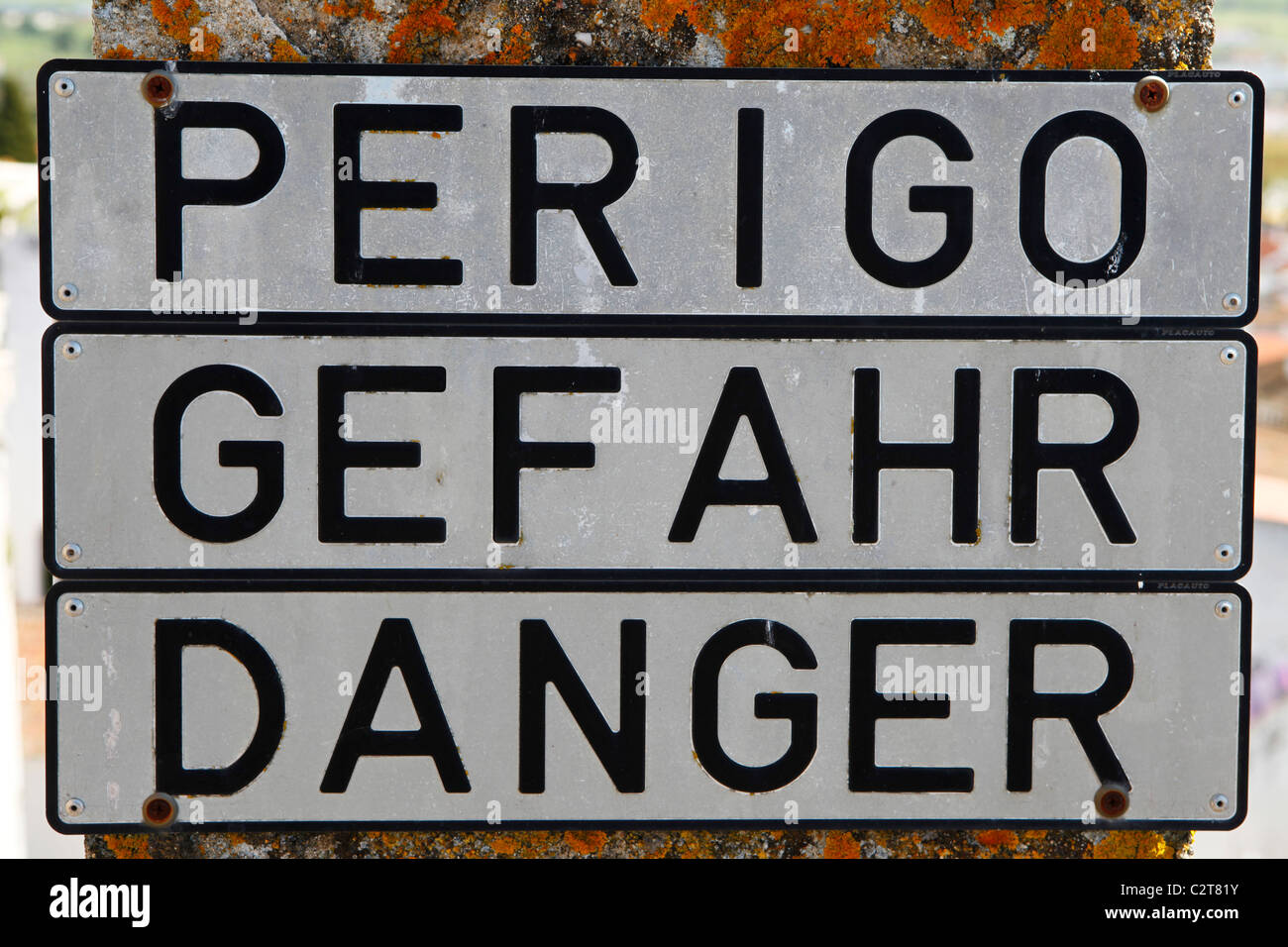 A sign warning of Danger in multiple languages Stock Photo - Alamy