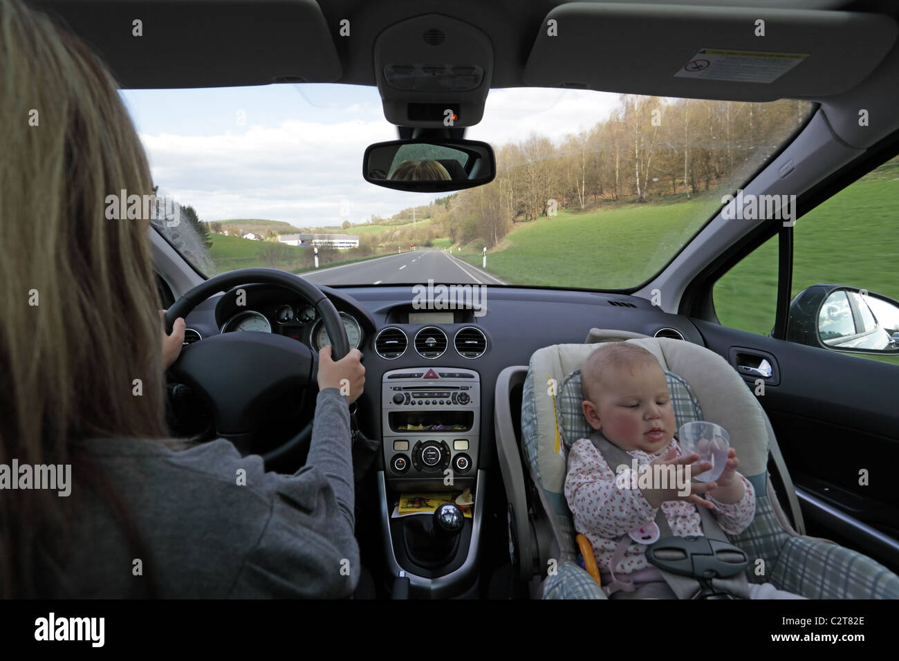 Mother driving car with the baby Stock Photo - Alamy