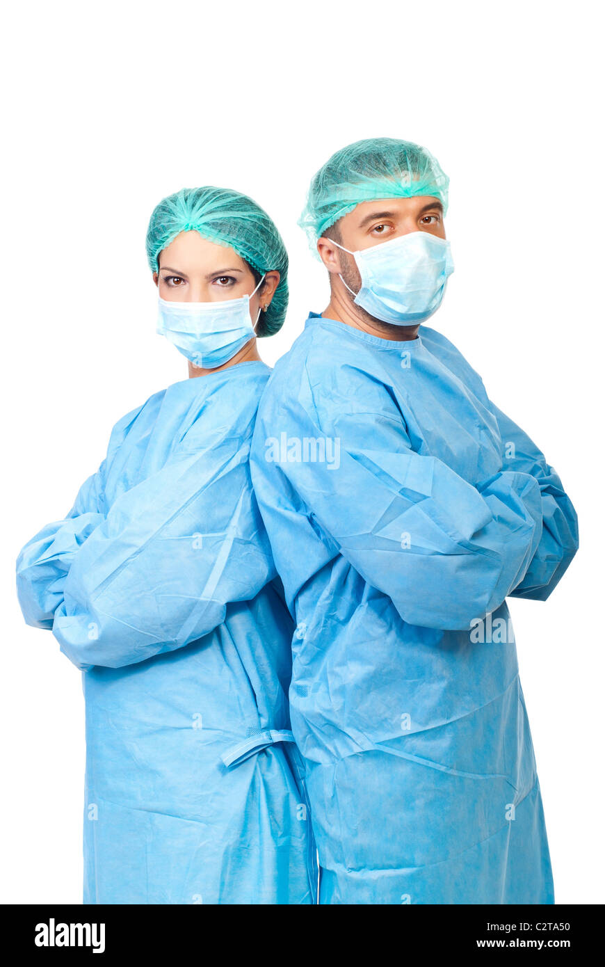 Two surgeons in sterile uniforms standing back to back with arms folded ...