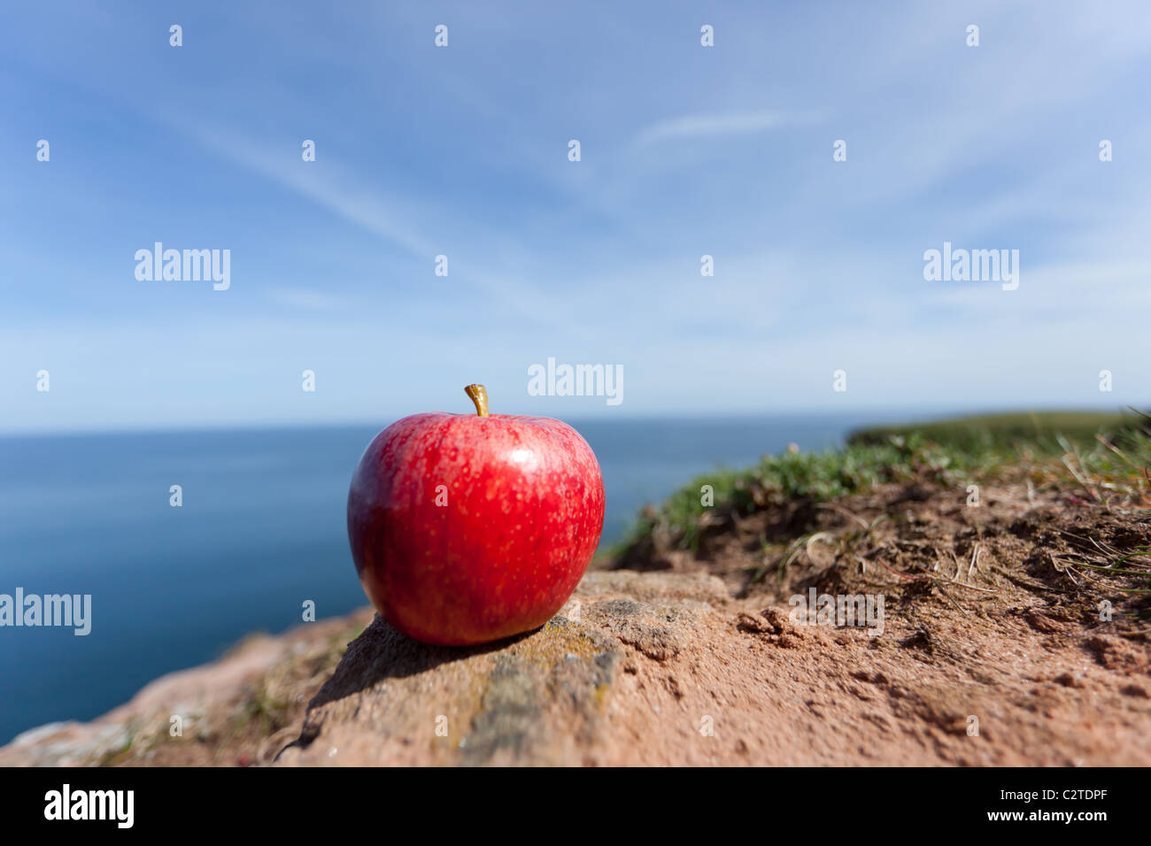 A bright red apple in front of a beautiful blue sky Stock Photo - Alamy
