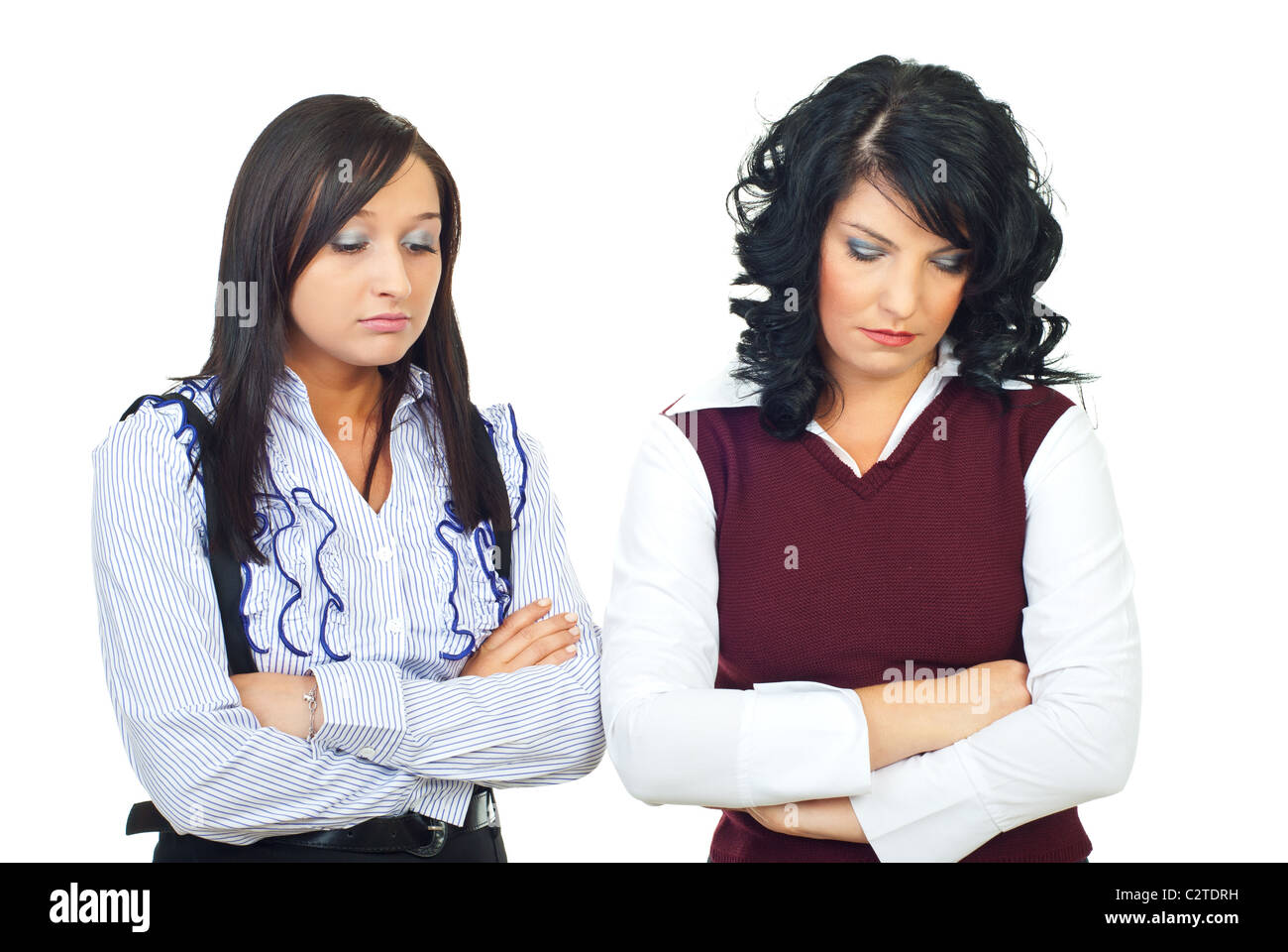 Two disappointed business women standing with arms folded and looking ...