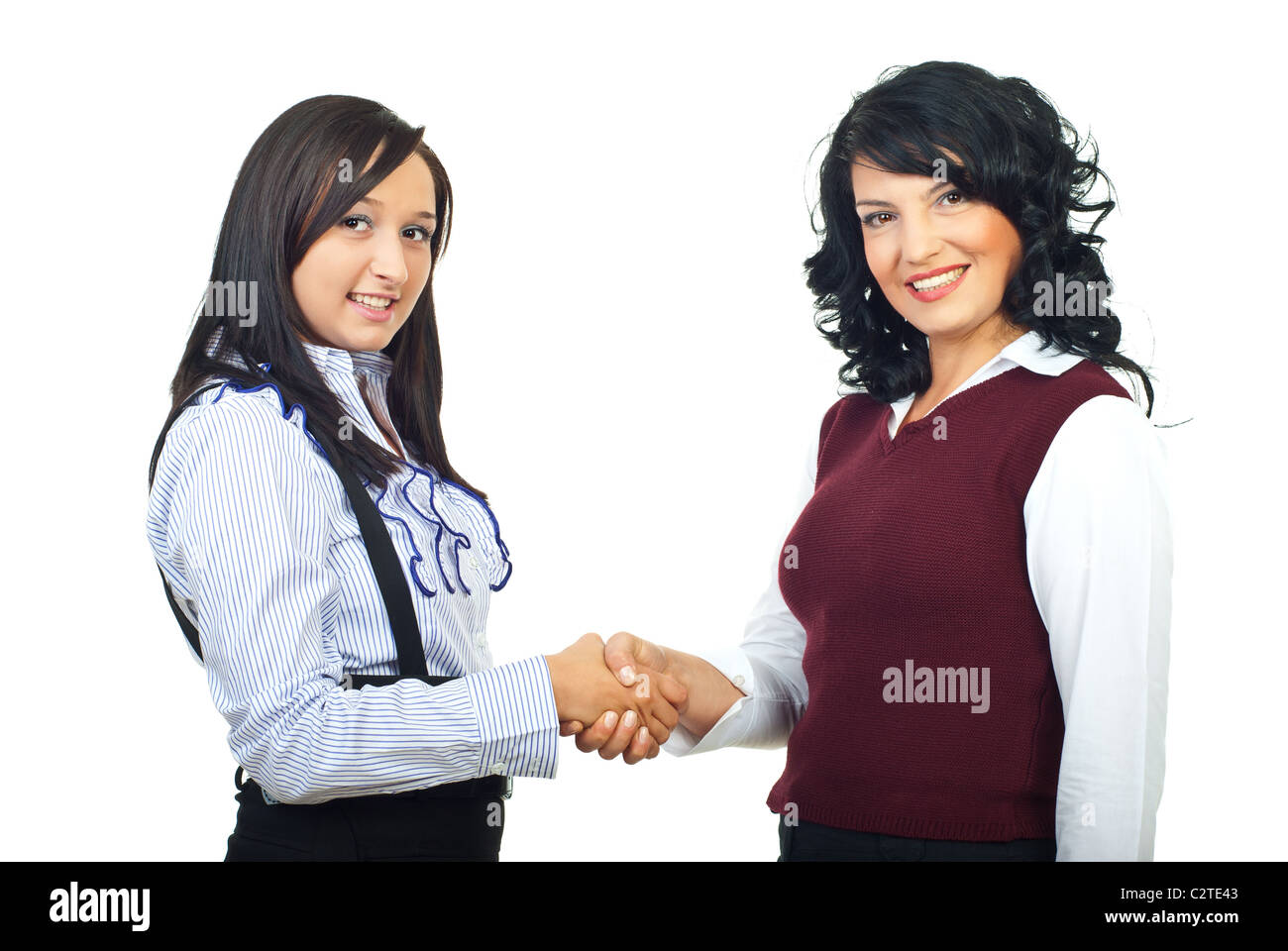 Two beautiful executives women shaking hands and looking to camera ...